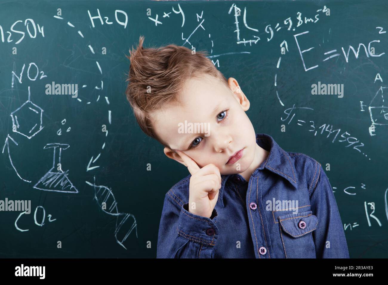 Genius boy near blackboard with formulas. Funny portrait clever pupil ...