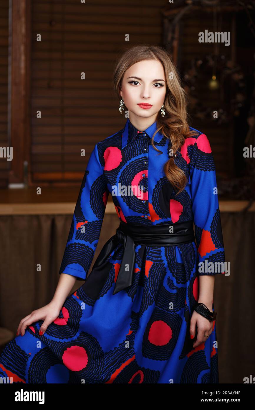 Portrait of a beautiful long-haired young girl in fashion motley dress ...