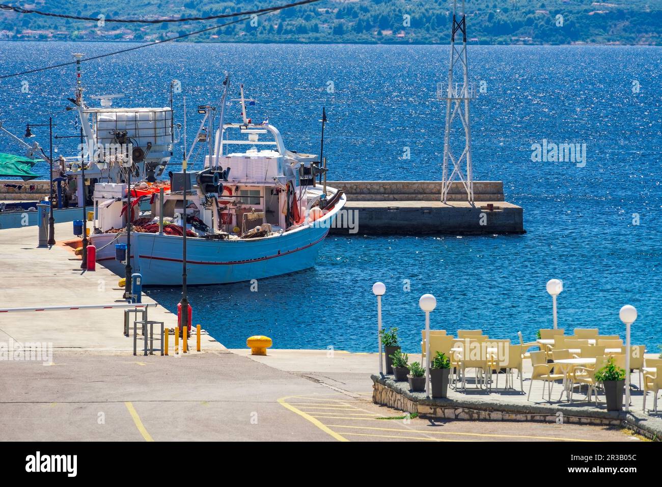 A traditional caique fishing boat with gear moored at a small port ...