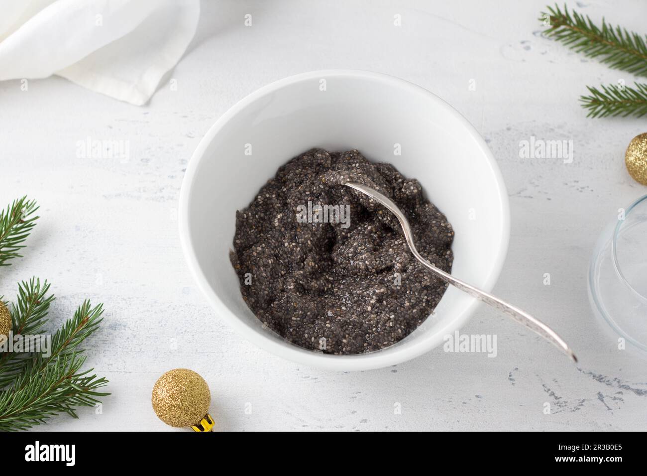 Ceramic bowl with soaked chia seeds on a light blue background. Cooking ...