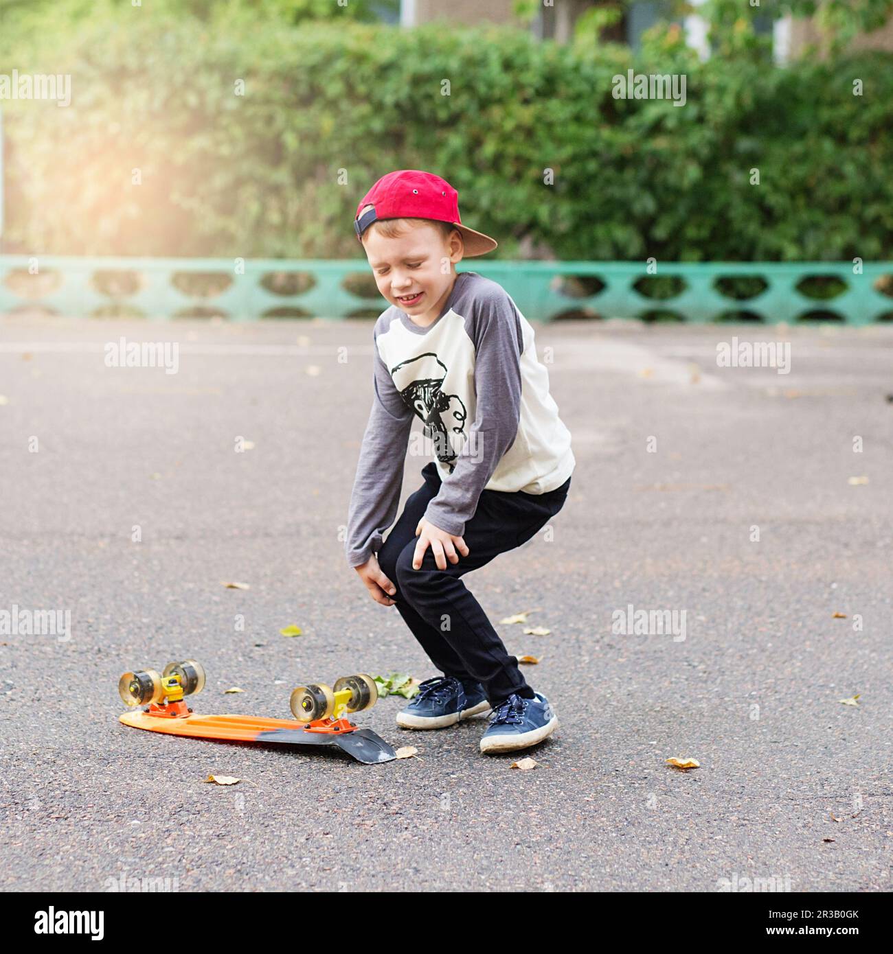 Little urban boy with a penny skateboard. Young kid riding in the park ...