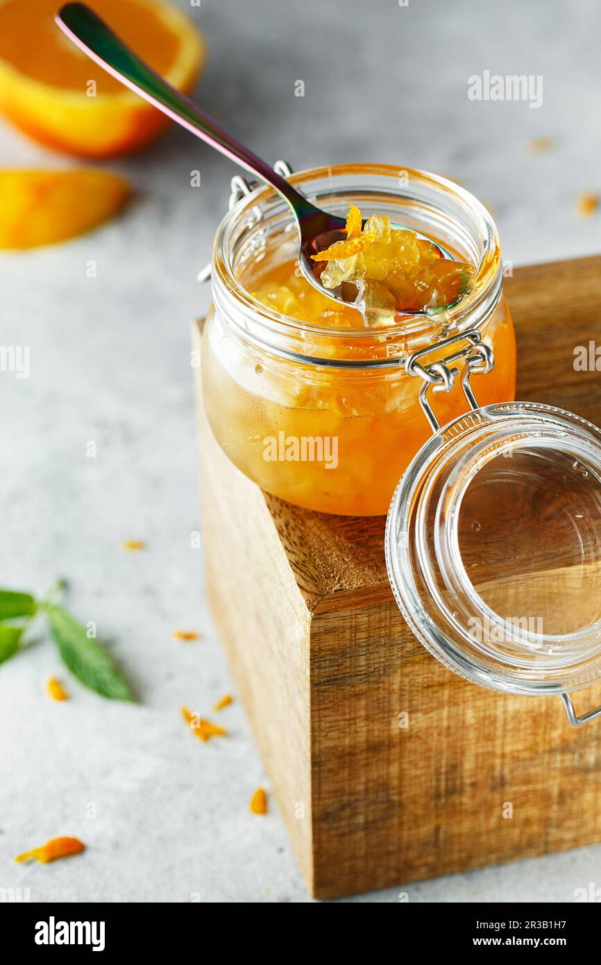 Homemade orange jam in glass jar on the wooden box on the gray ...