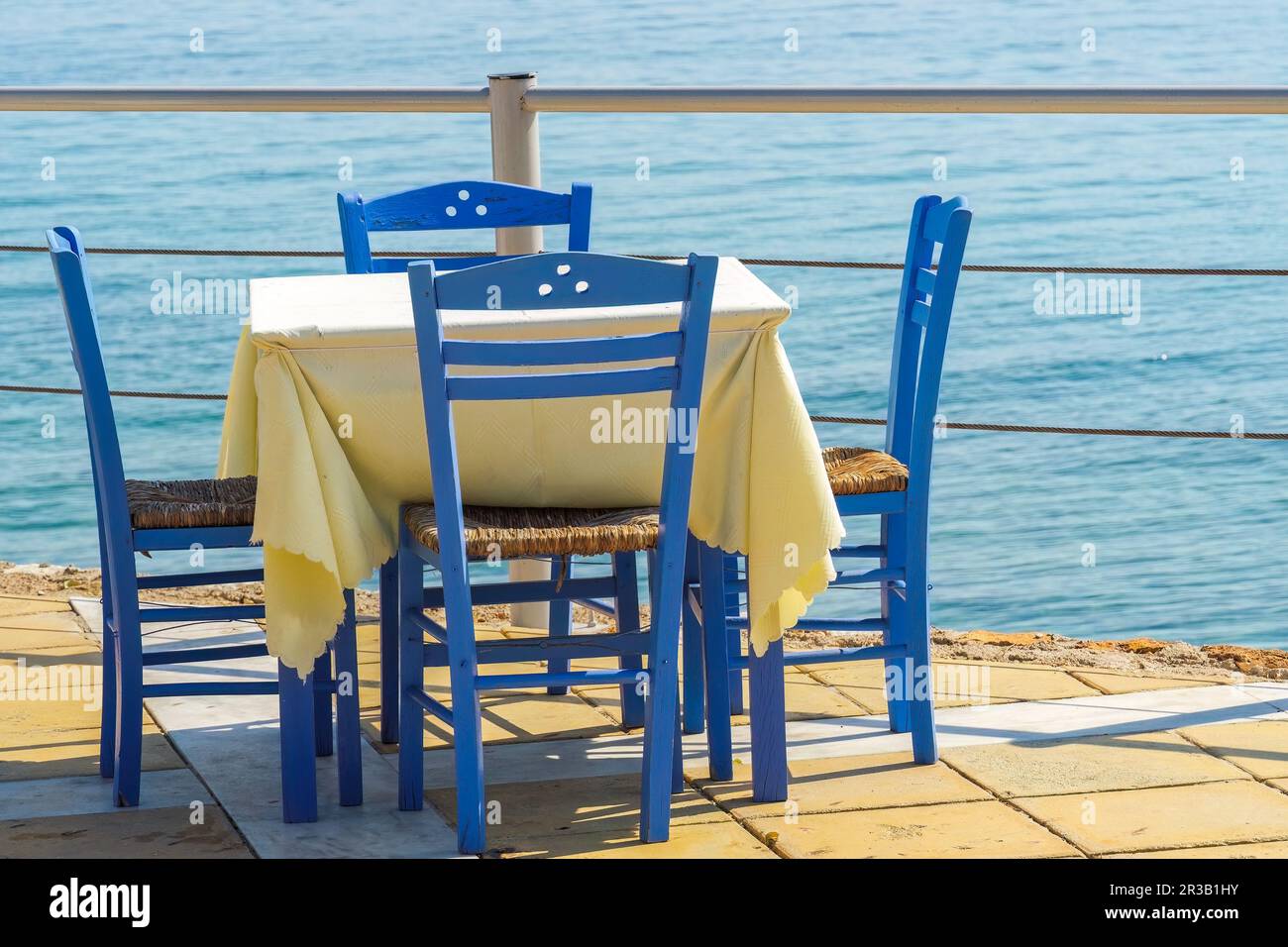 Empty tavern restaurant by the seafront with wooden chairs and tables ...