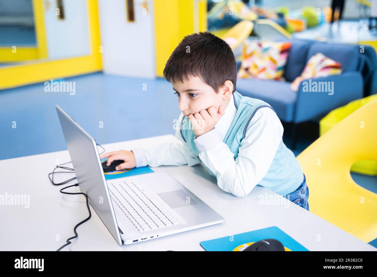 Focused boy using laptop at desk in computer class Stock Photo - Alamy