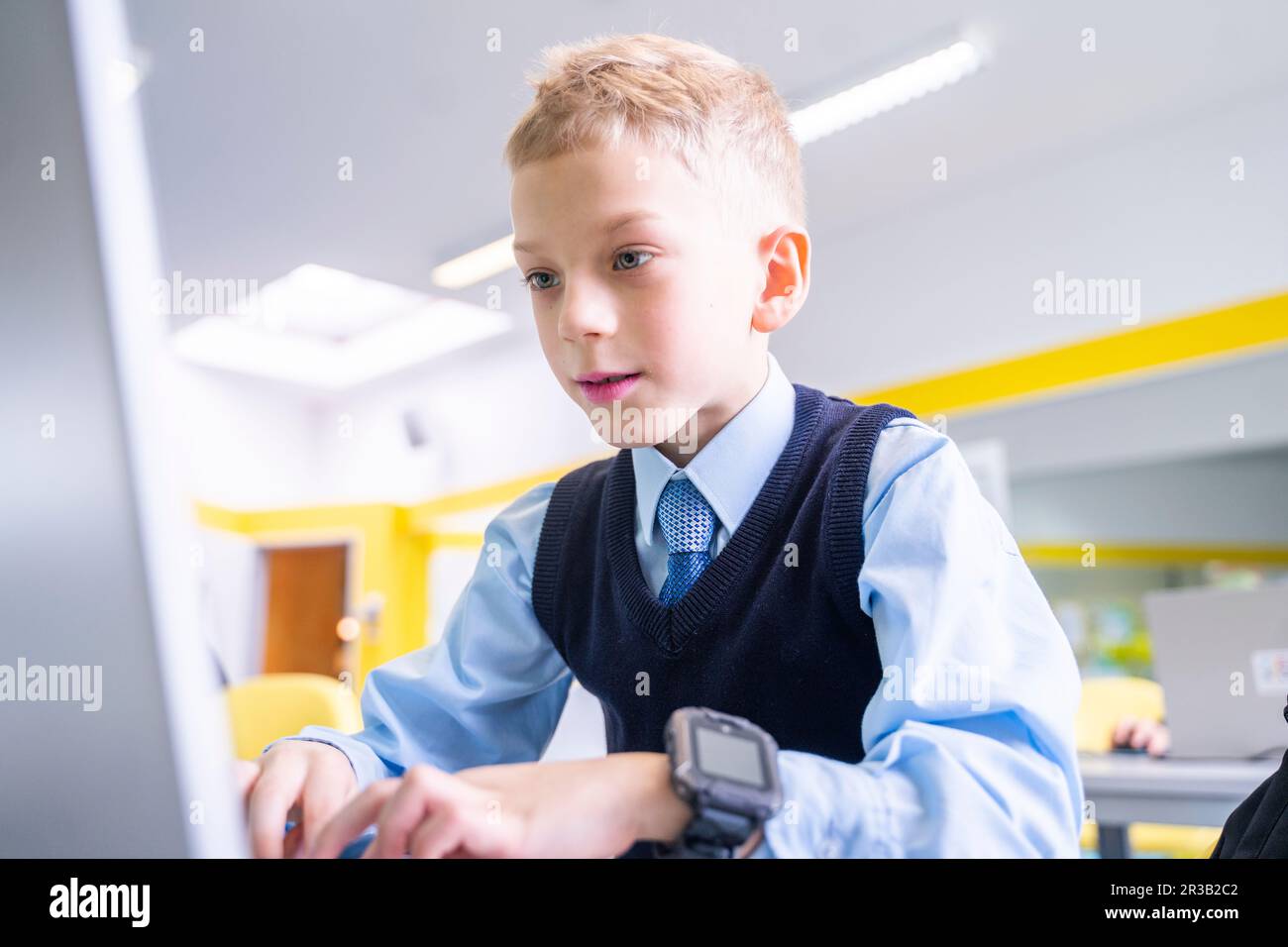 Concentrated boy using laptop in computer class Stock Photo - Alamy