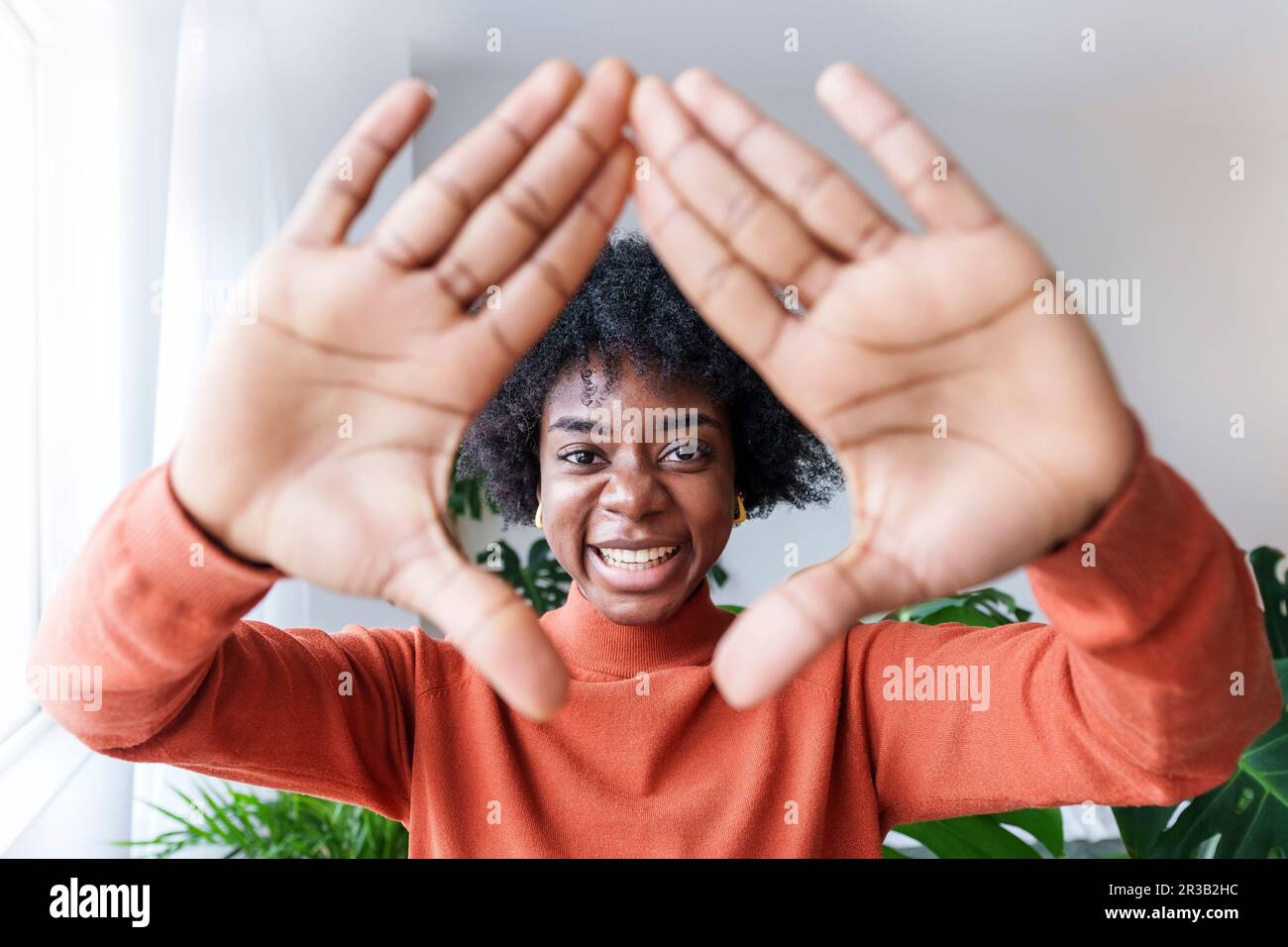 Happy young woman making finger frame Stock Photo - Alamy