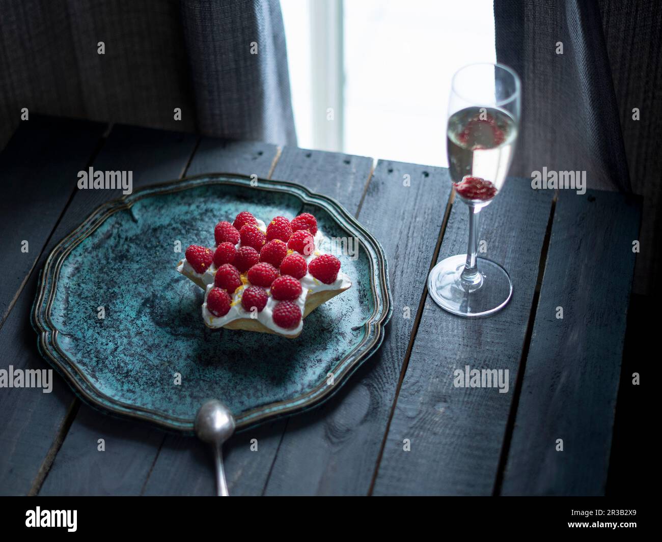 A star shaped ricotta cake with raspberries and a glass of champage ...