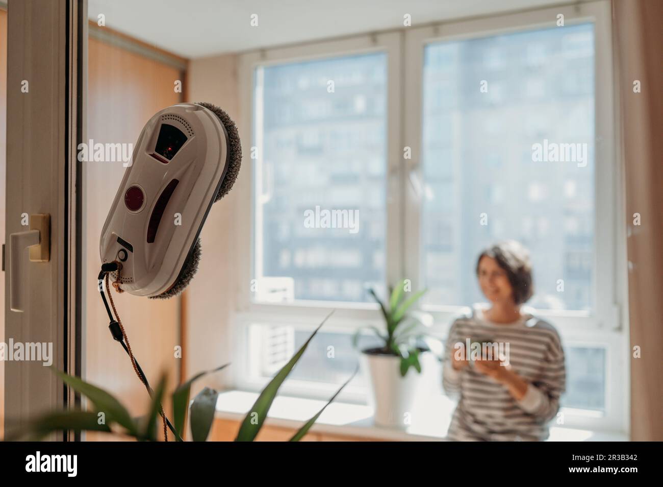 Window cleaner on glass with woman in background Stock Photo - Alamy