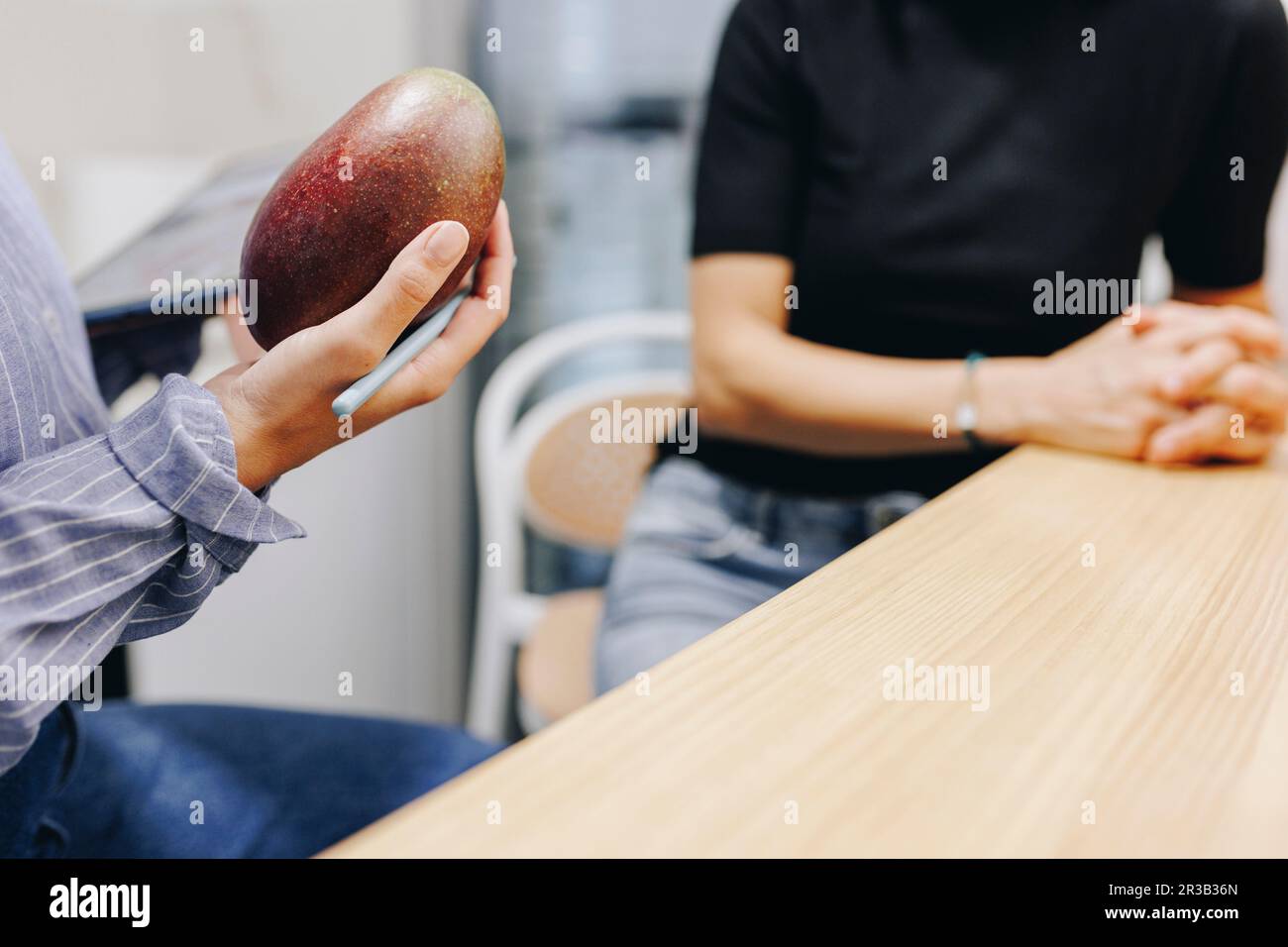 Hand holding mango hi-res stock photography and images - Alamy