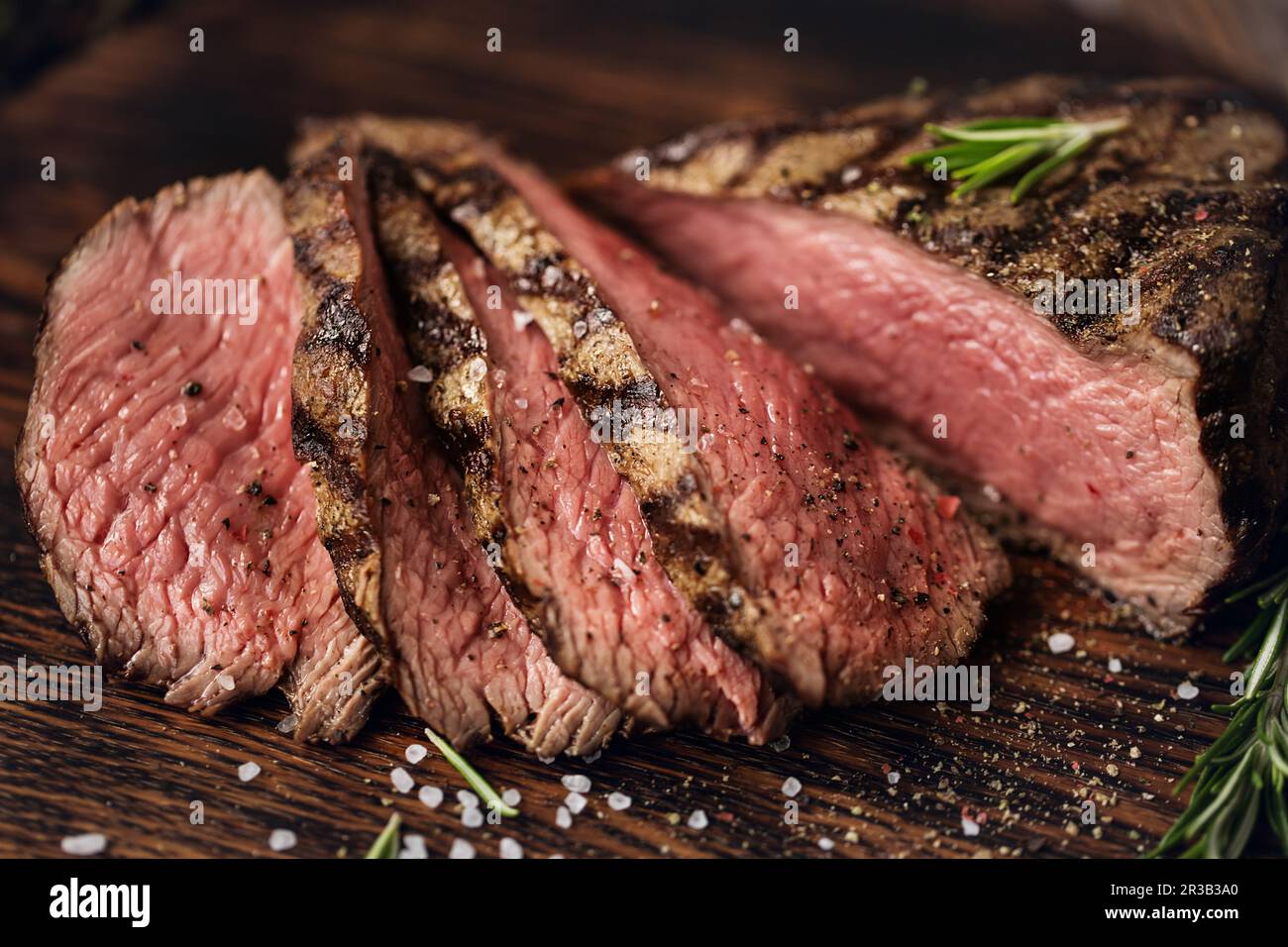 Juicy medium Beef Rib Eye steak slices on wooden board with herbs ...