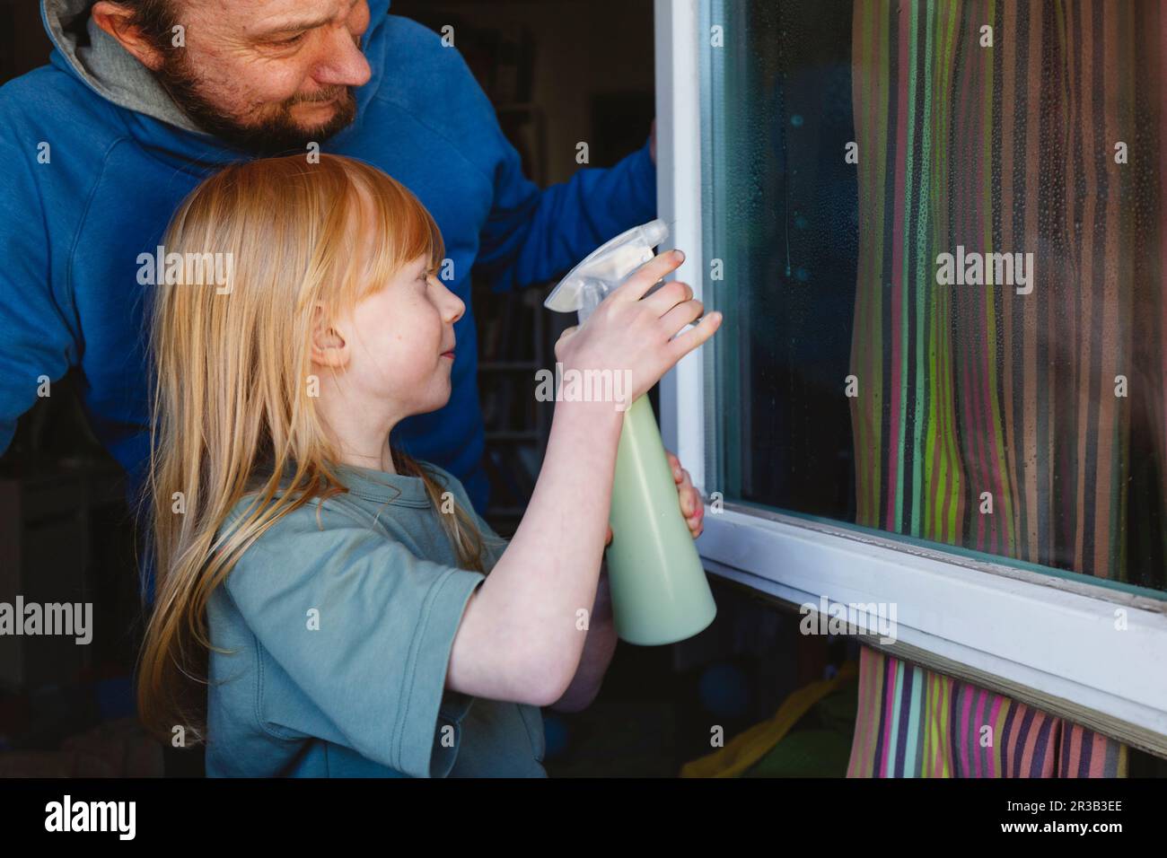 Girl cleaning window with father at home Stock Photo - Alamy