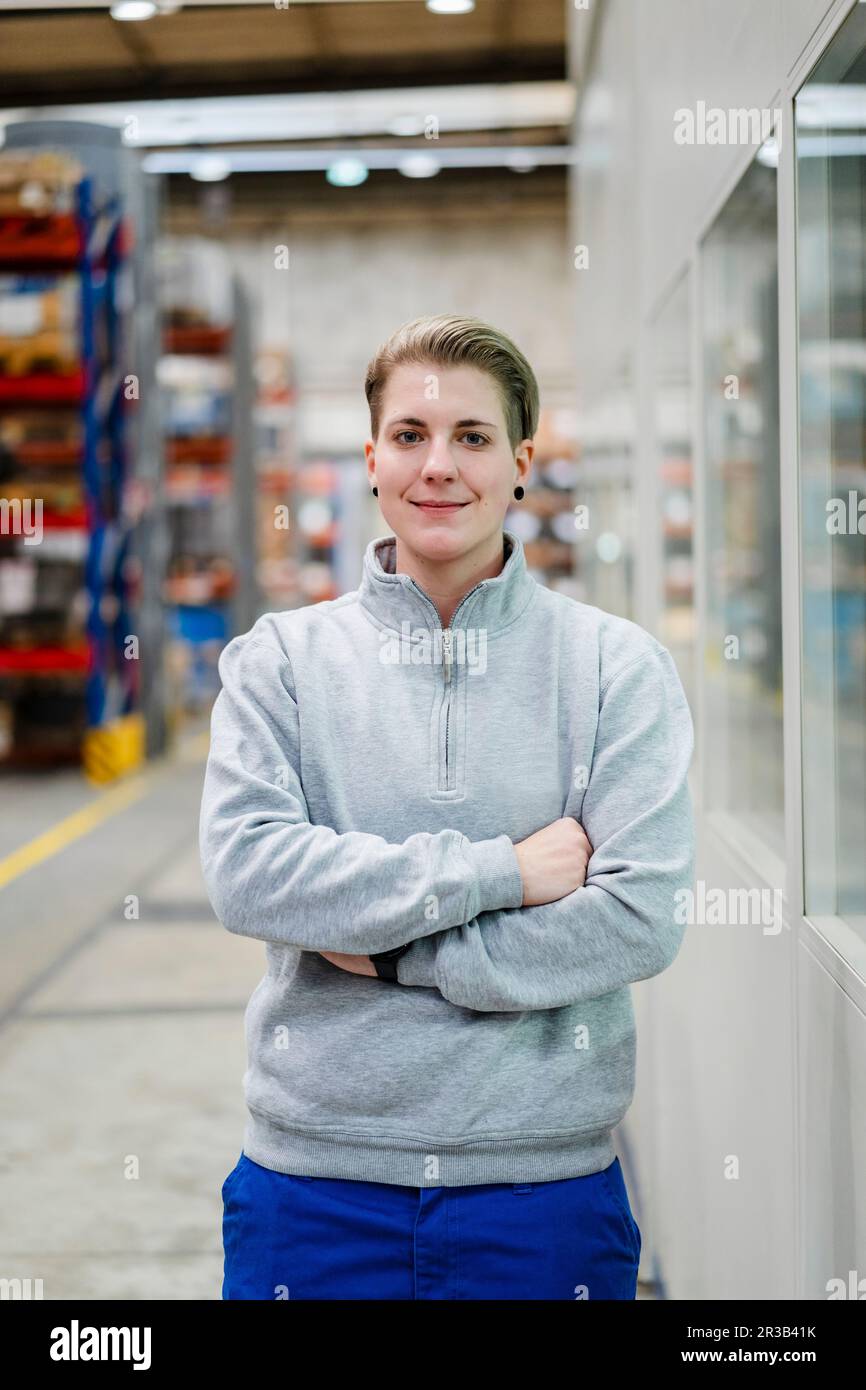Confident young employee standing with arms crossed at factory Stock ...