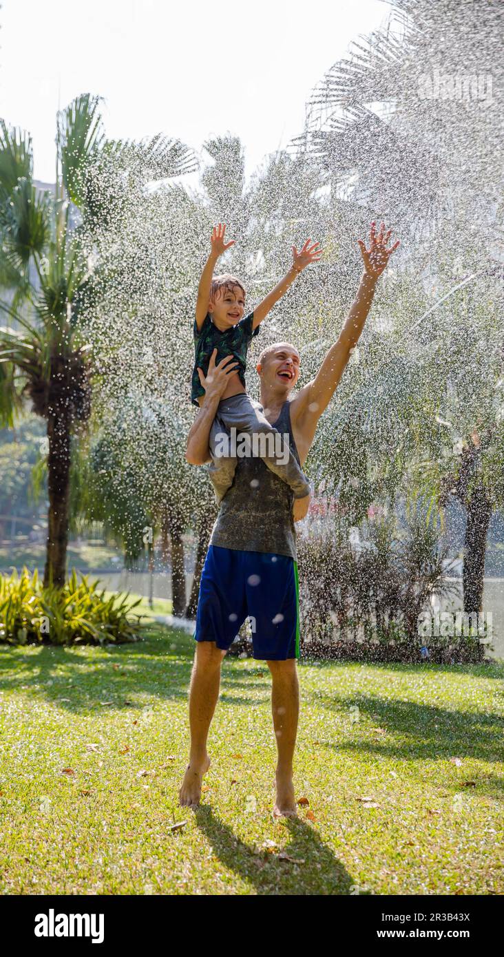 Happy man and son having fun in rain Stock Photo - Alamy