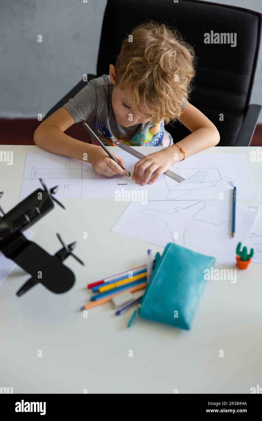 Boy drawing on paper with pencil at home Stock Photo - Alamy