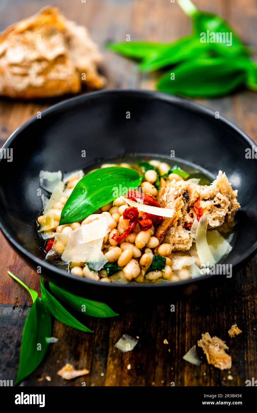 White beans with wild garlic, dried tomatoes and bread Stock Photo - Alamy