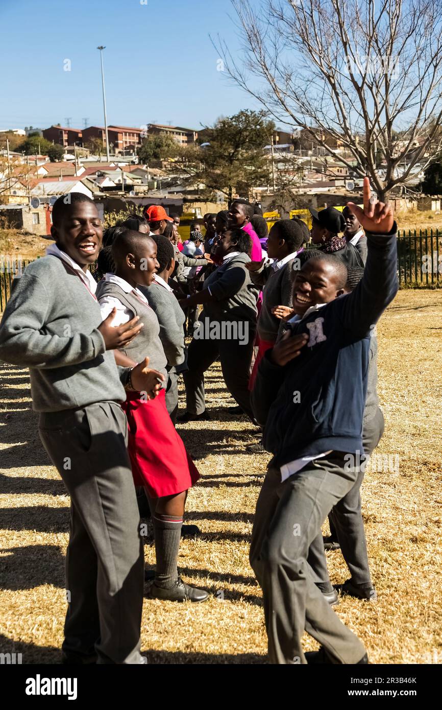 Diverse African high school pupils playing physical games on the sports ...