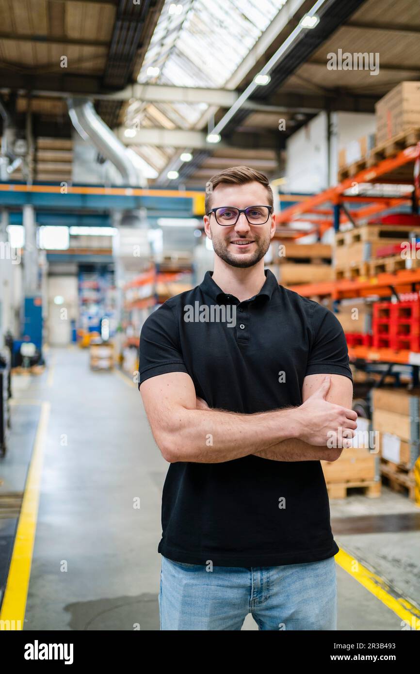 Employee wearing eyeglasses standing with arms crossed at factory Stock ...