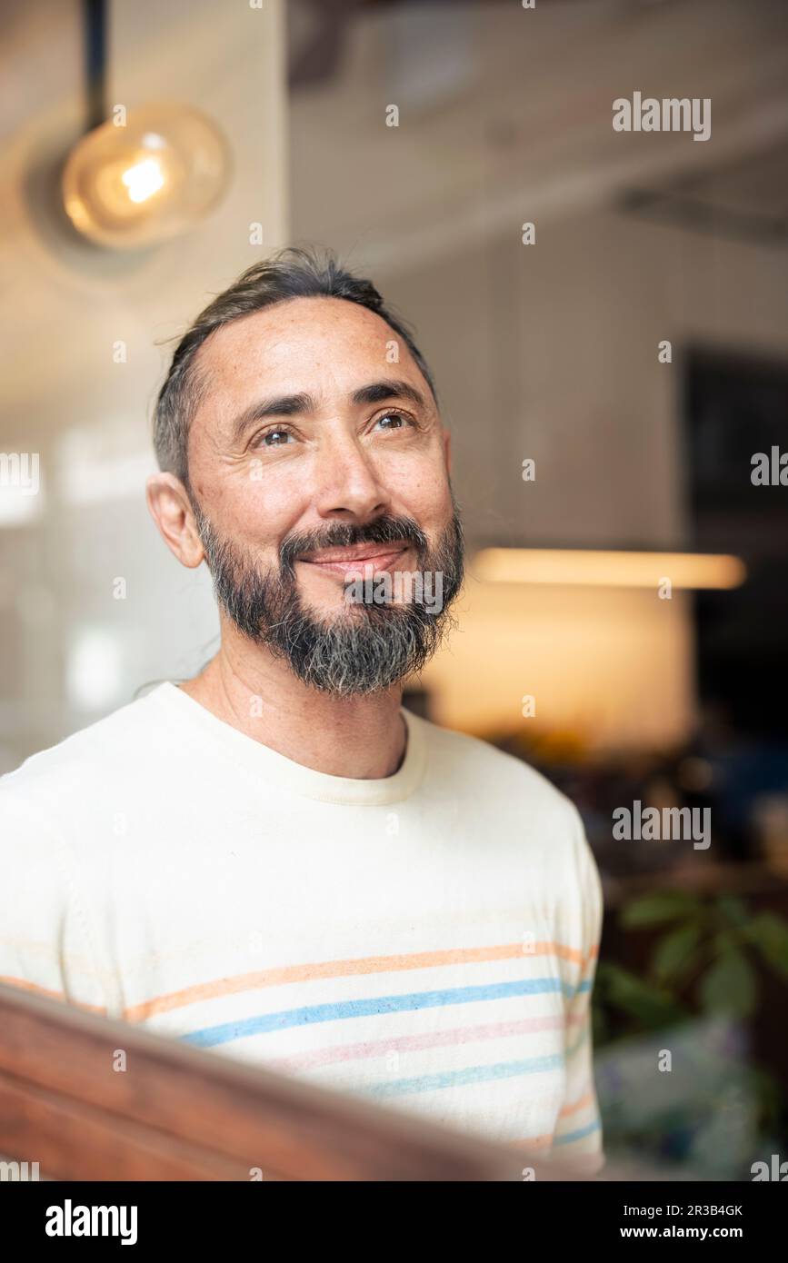 Mature man day dreaming at cafe seen through glass window Stock Photo ...