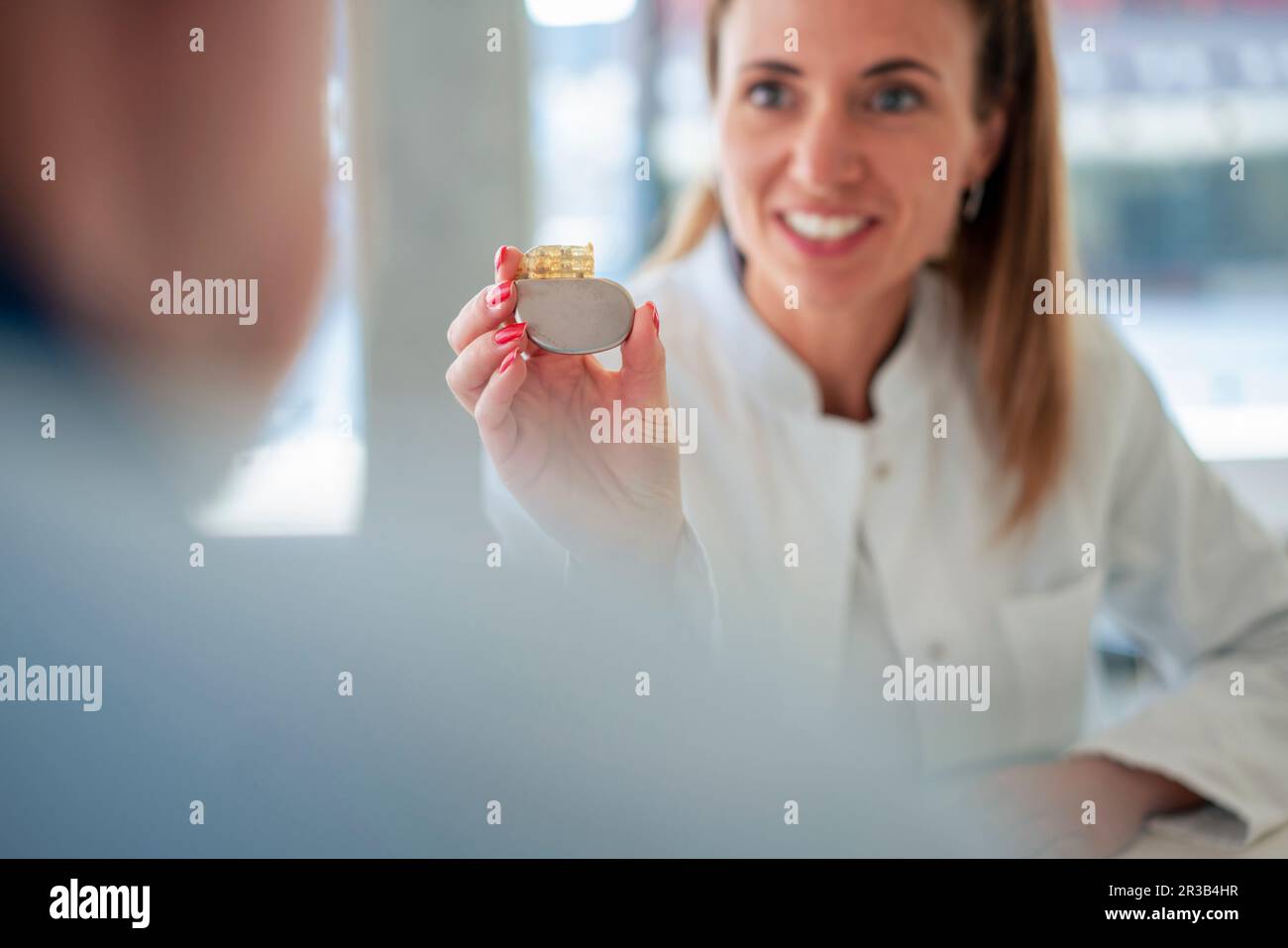 Doctor showing heart pacemaker to patient at clinic Stock Photo - Alamy