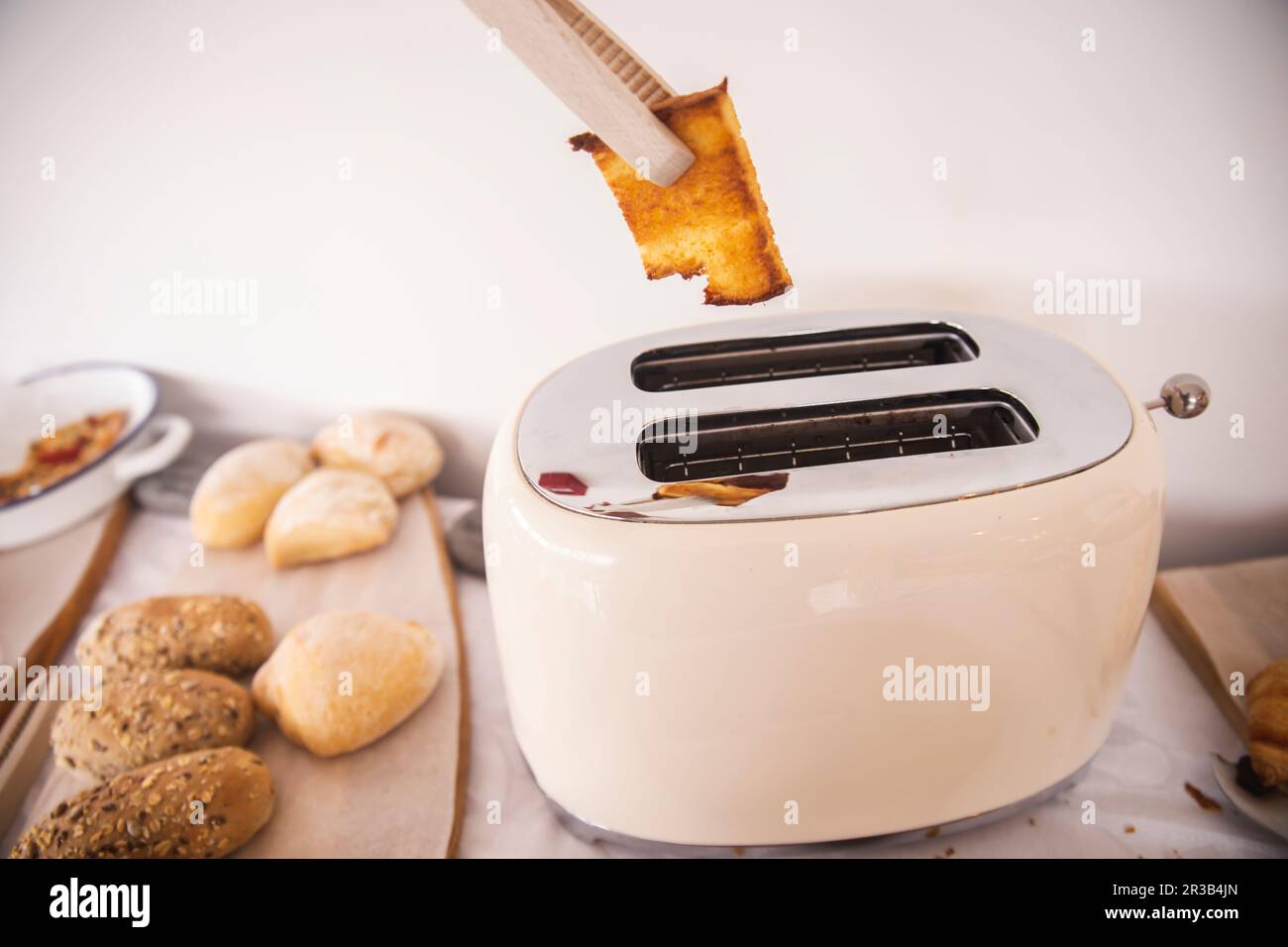 Cooking tongs removing bread toast from toaster Stock Photo - Alamy