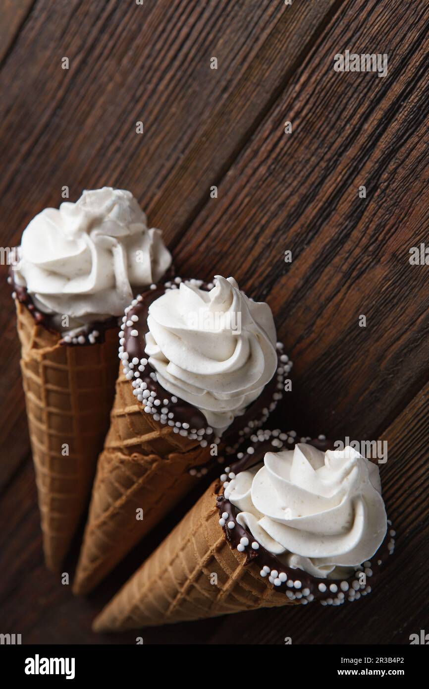 Ice cream cones on wooden table. Soft ice creams or frozen custard in ...