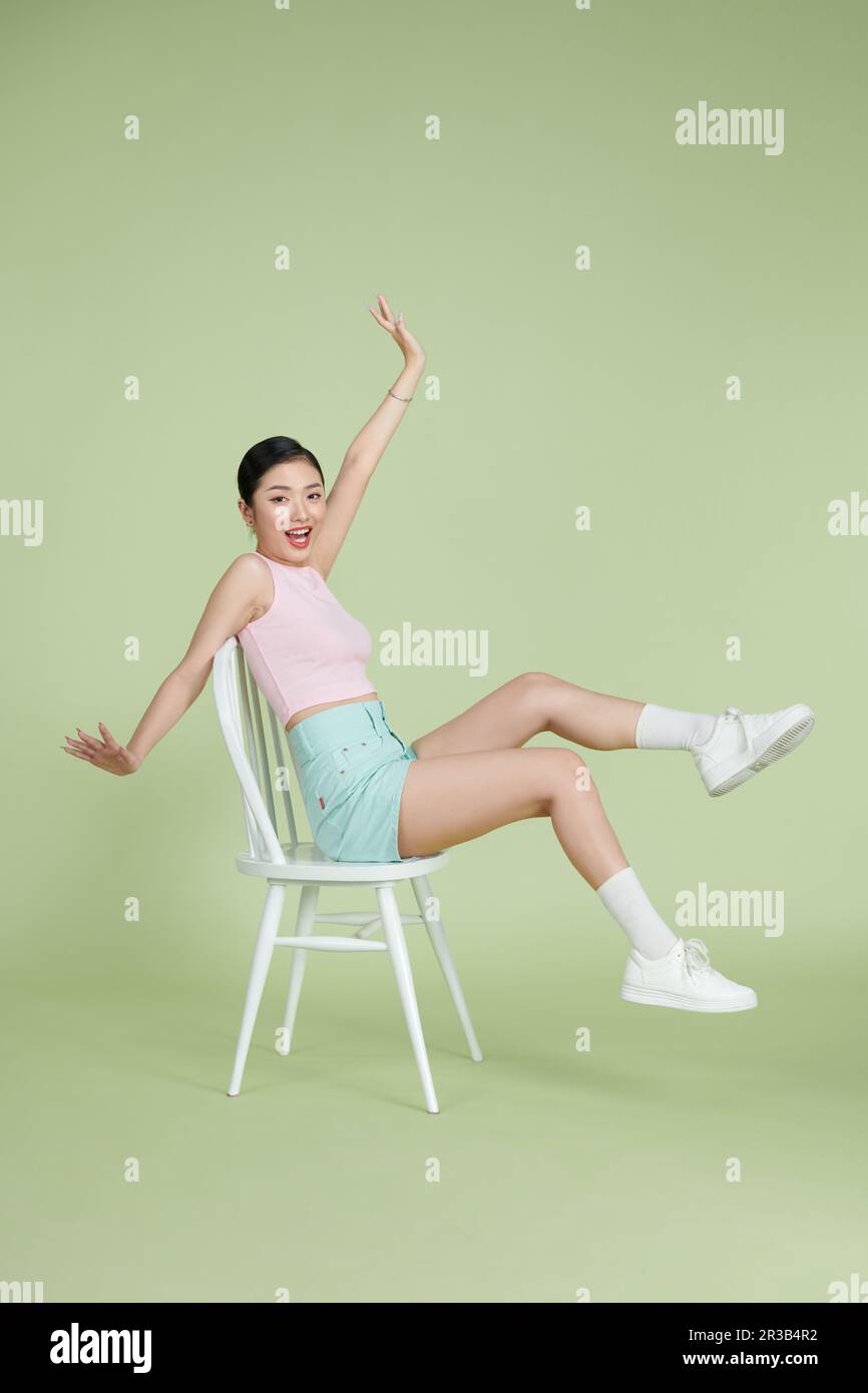Photo of sweet excited woman smiling rising arms sitting chair isolated ...