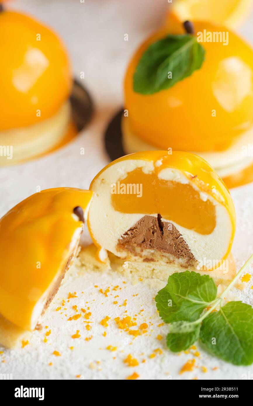 Mousse dessert with orange zest and mint in the shape of an orange ...