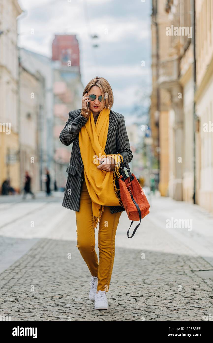 Woman walking on street talking hi-res stock photography and images - Alamy