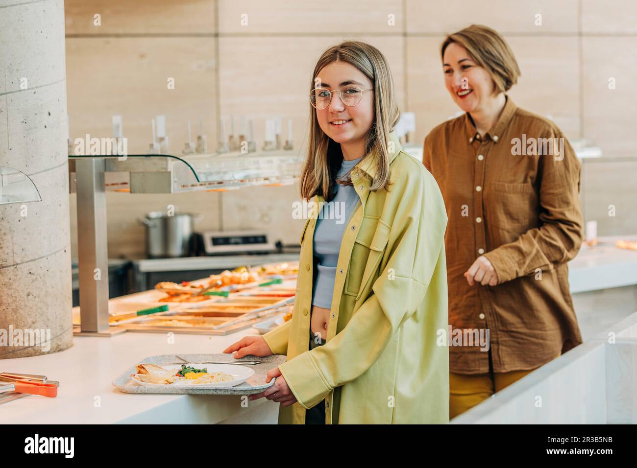 Smiling mother and daugther taking food at buffet in cafe Stock Photo ...