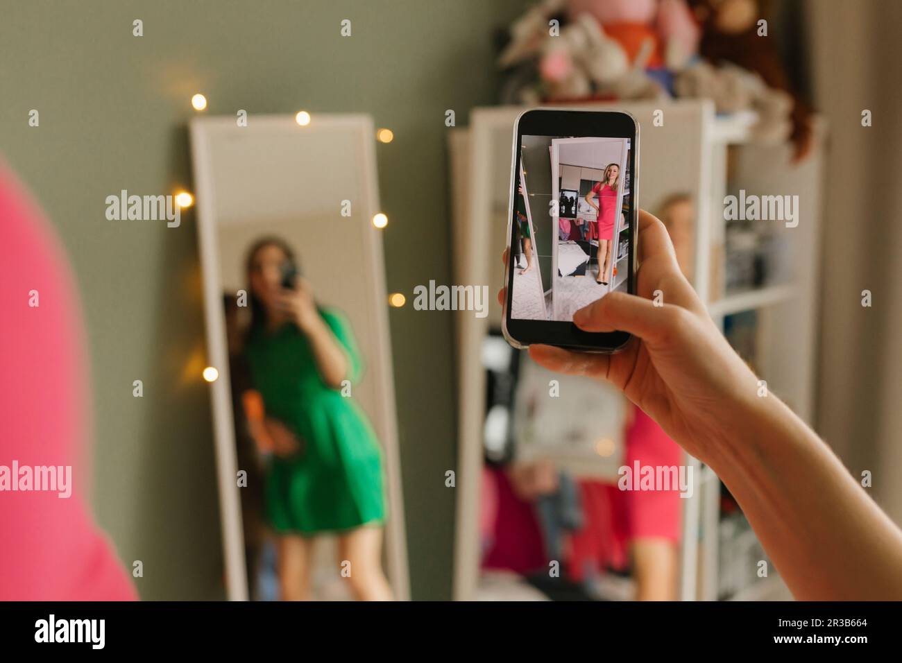 Hand of woman taking picture of friend getting ready for party at home ...