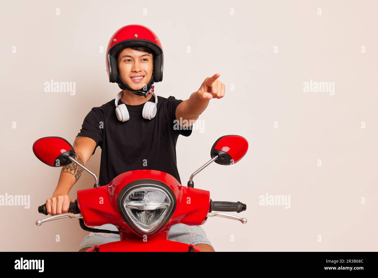 Young guy in red helmet and black t-shirt rides red motor bike with ...