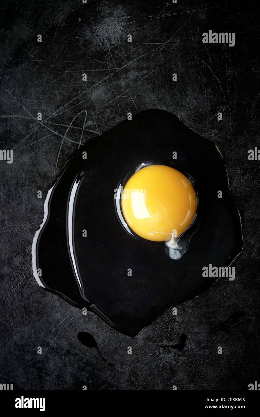 An open egg on a black metal background Stock Photo - Alamy