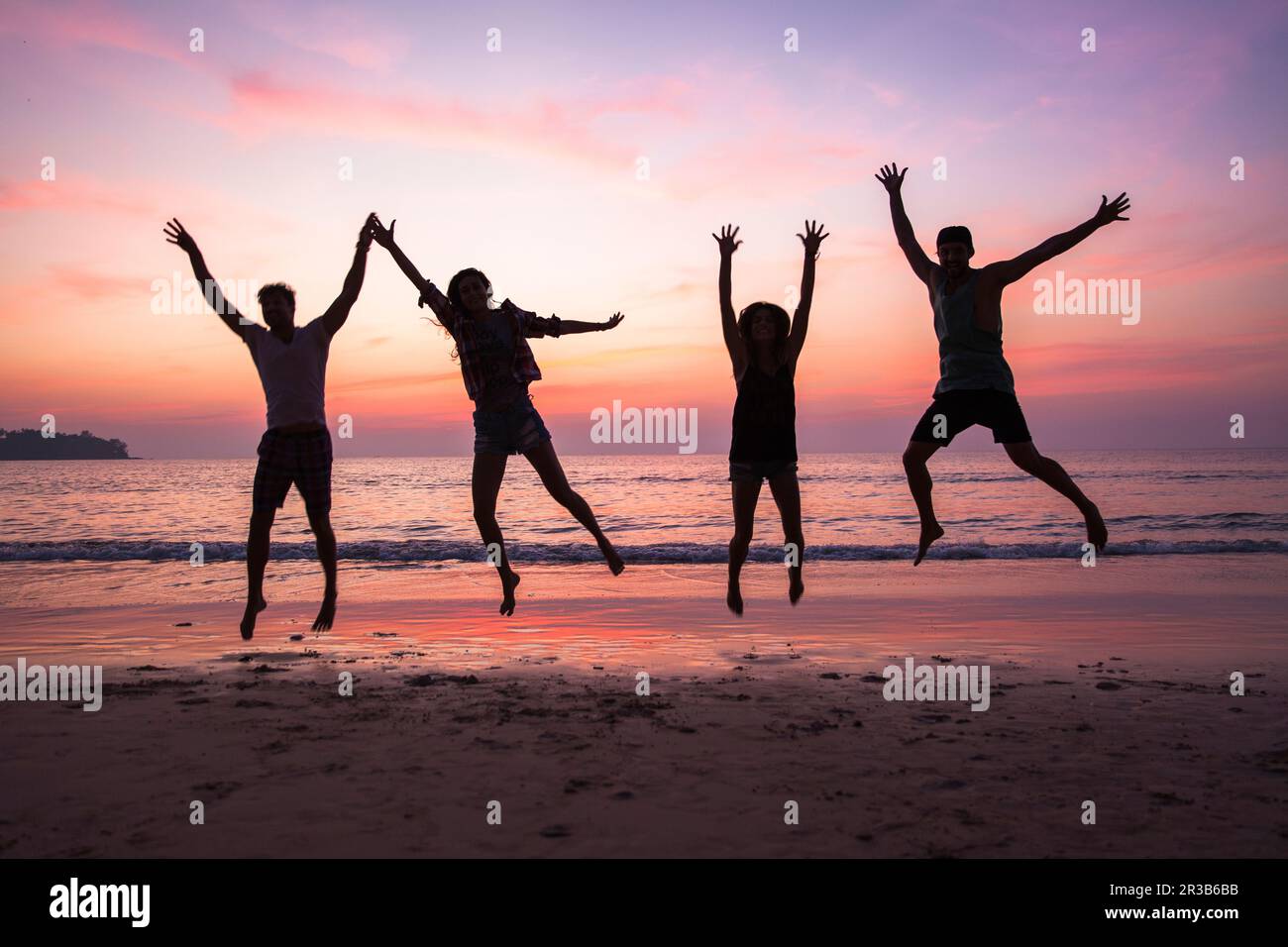 Four friends jumping on beach hi-res stock photography and images - Alamy