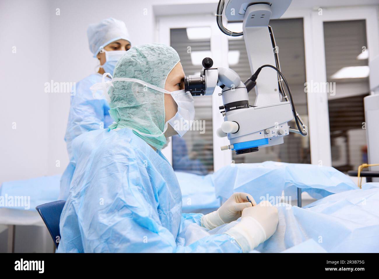 Surgeon performing eye surgery with microscope in operating room Stock ...