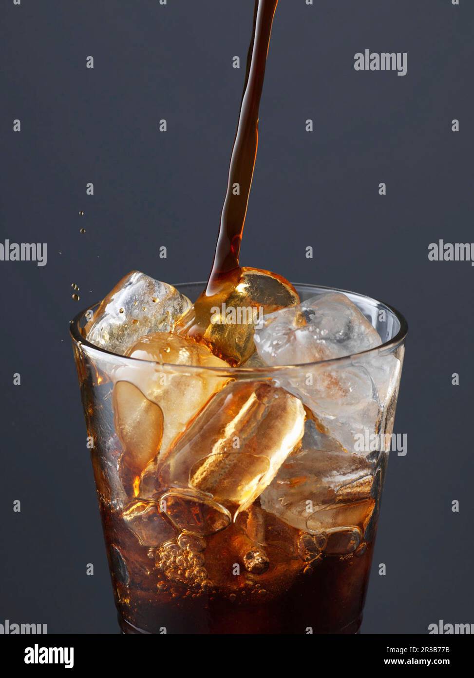 Iced coffee - Pouring coffee on ice cubes Stock Photo - Alamy