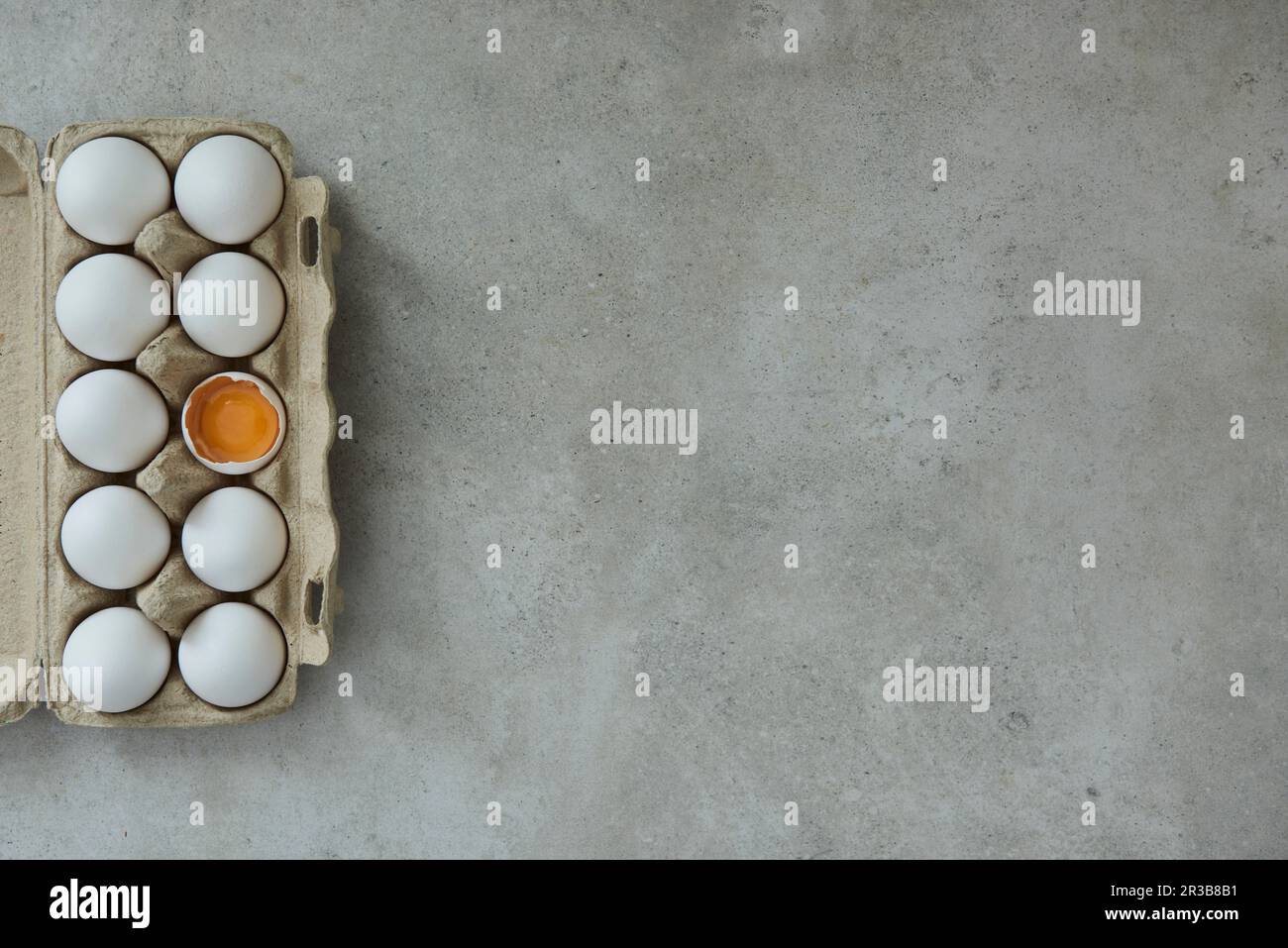 Eggs in an egg box, one of them opened Stock Photo - Alamy