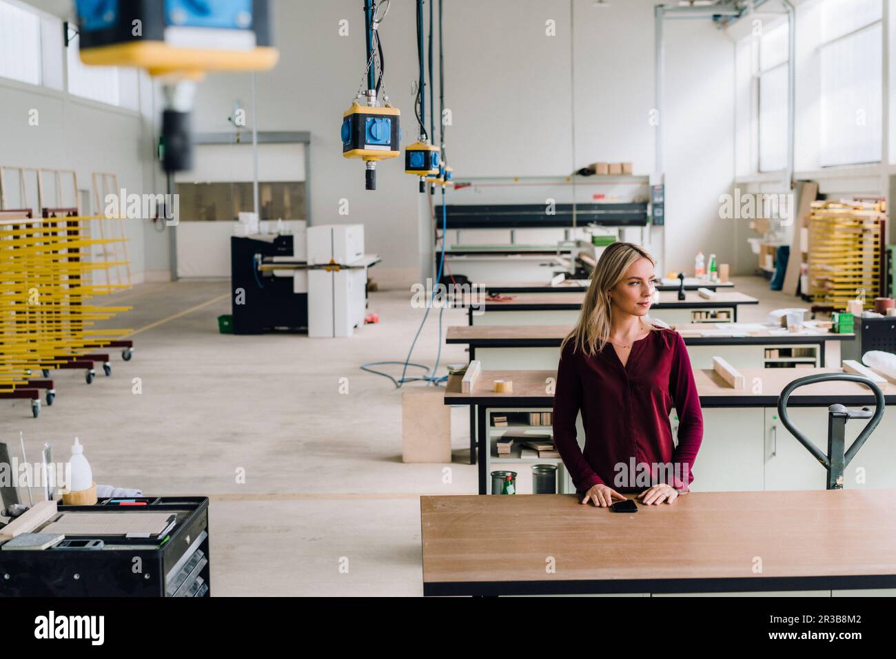 Businesswoman standing near workbench at factory Stock Photo - Alamy