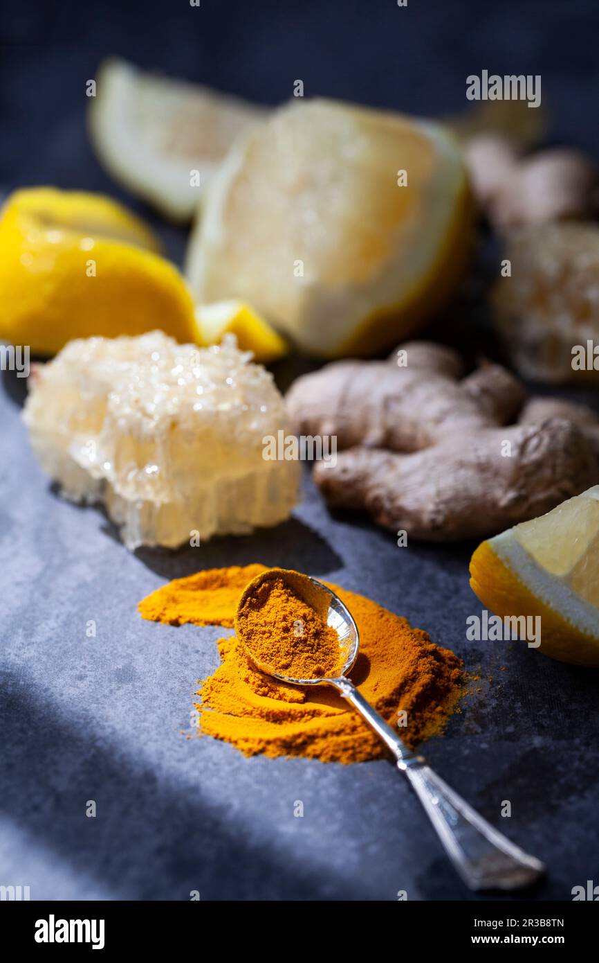 Lemon, turmeric powder, ginger, and honeycomb on a blue surface Stock ...