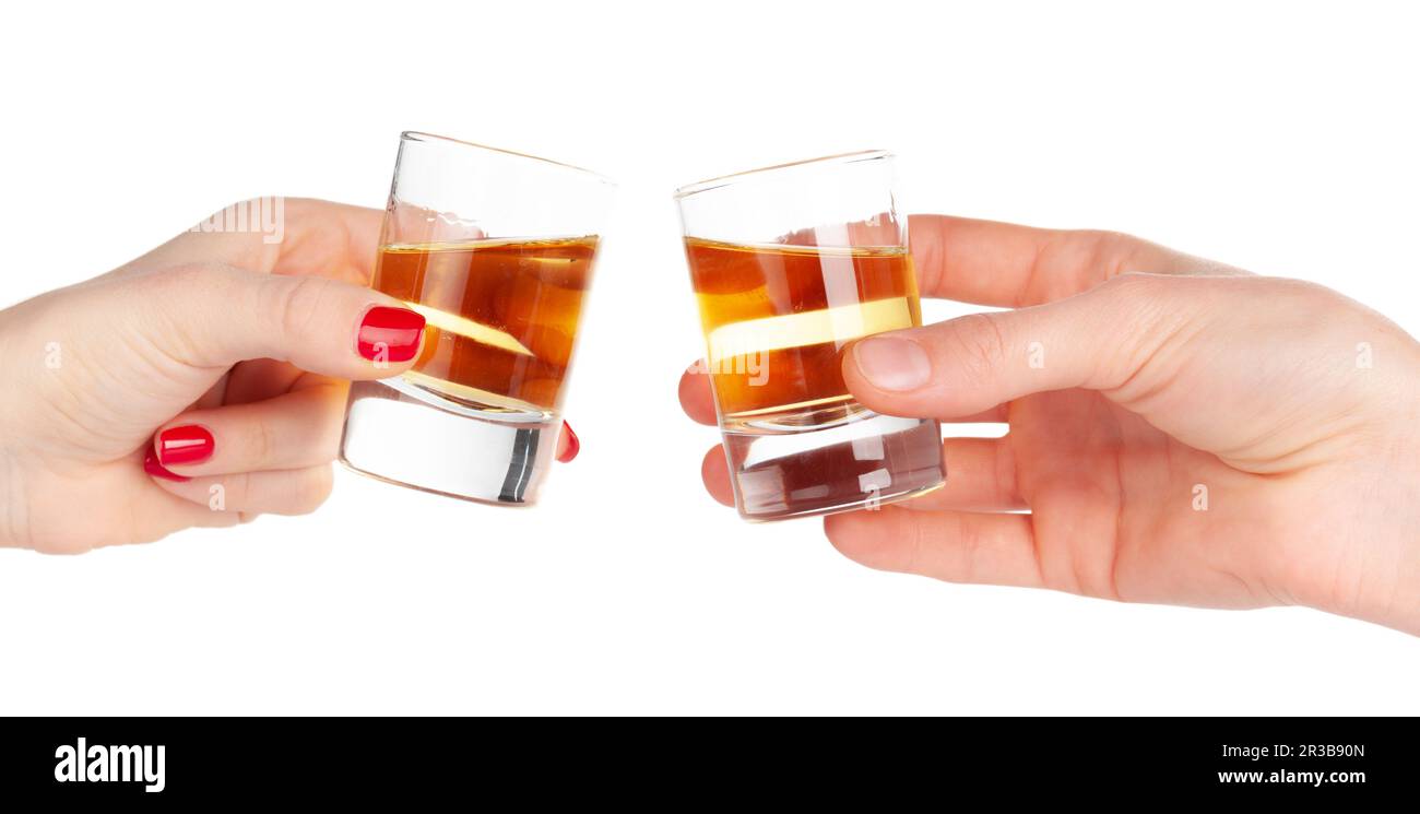 Two hands clinking shots of alcoholic beverage together Stock Photo - Alamy