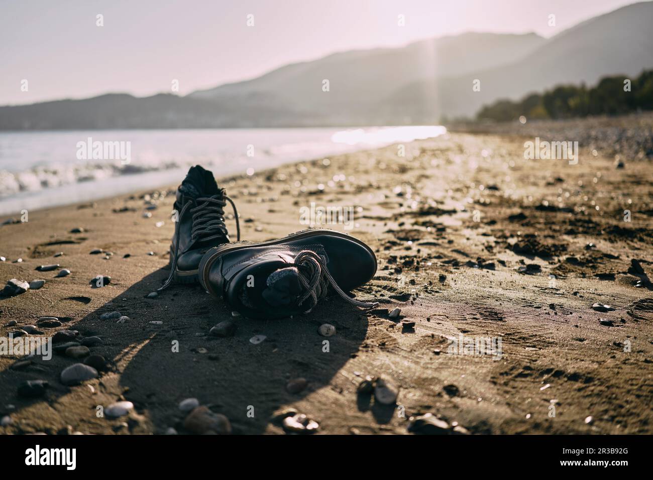 Pair of boots on sand at beach Stock Photo - Alamy