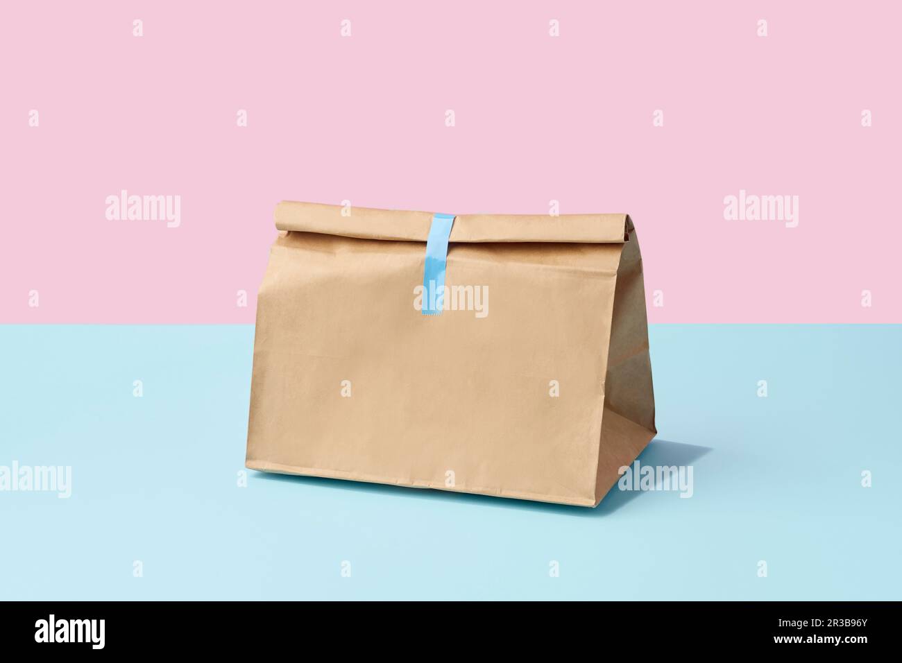 A closed paper bag against a blue and pink background Stock Photo - Alamy