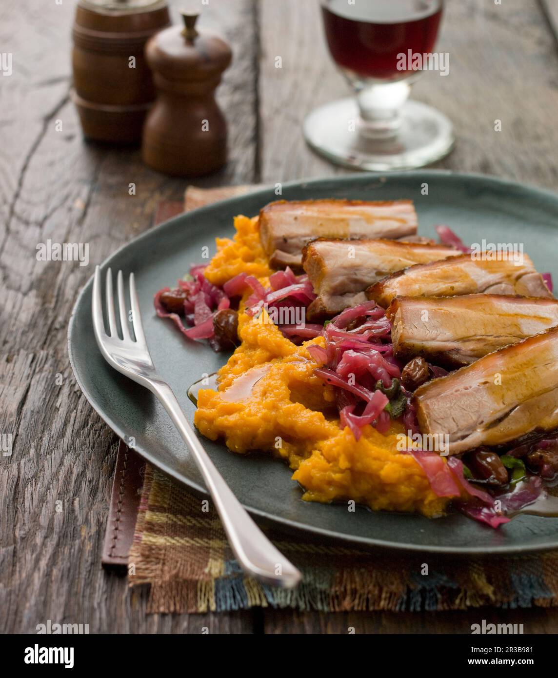 Pork belly on a bed of sweet potato mash, red cabbage with gravy Stock ...