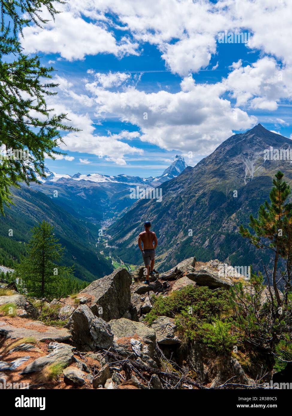 Travelling in Switzerland, a man with backpack standing on the rock ...