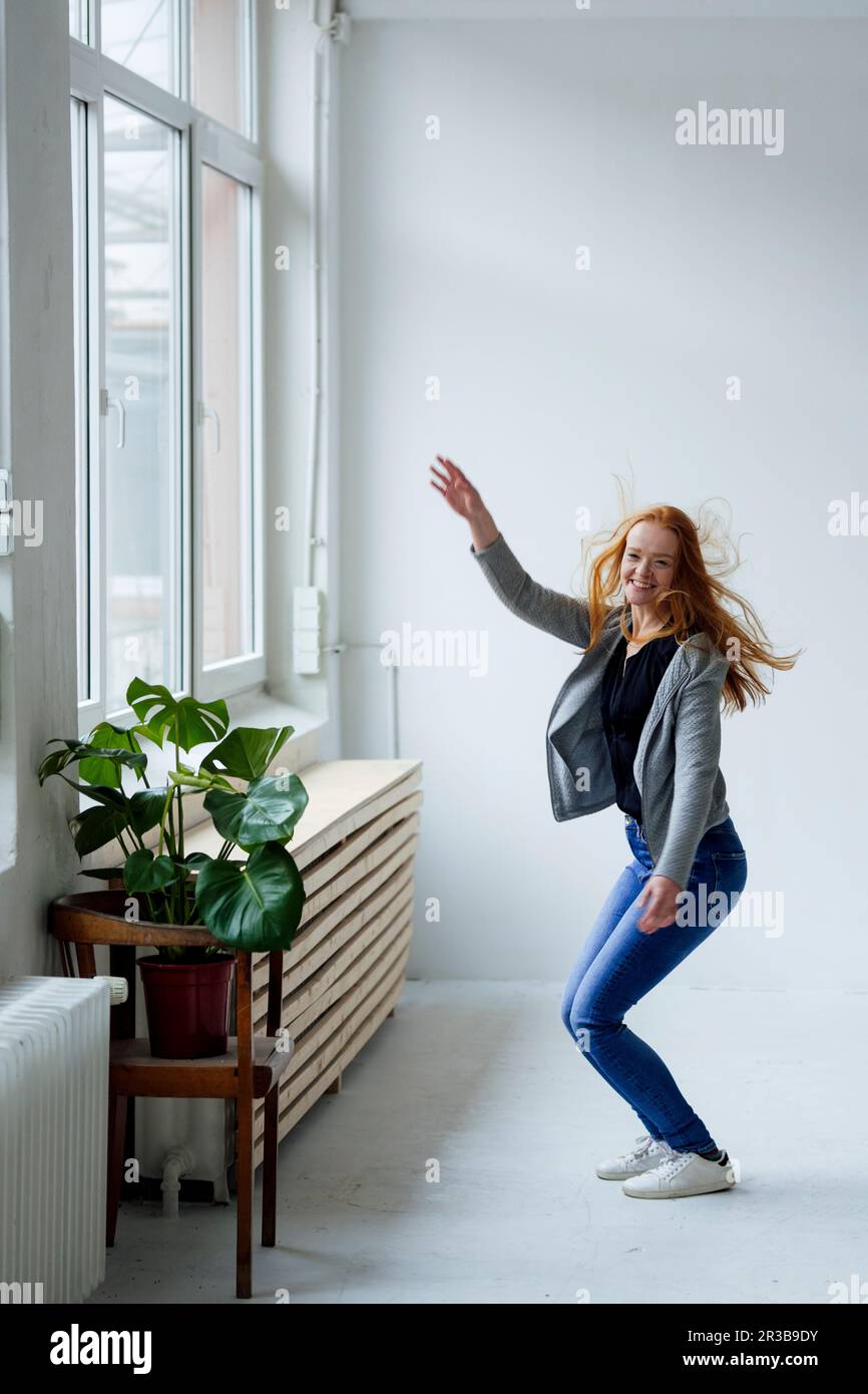 Cheerful woman dancing at the window Stock Photo - Alamy