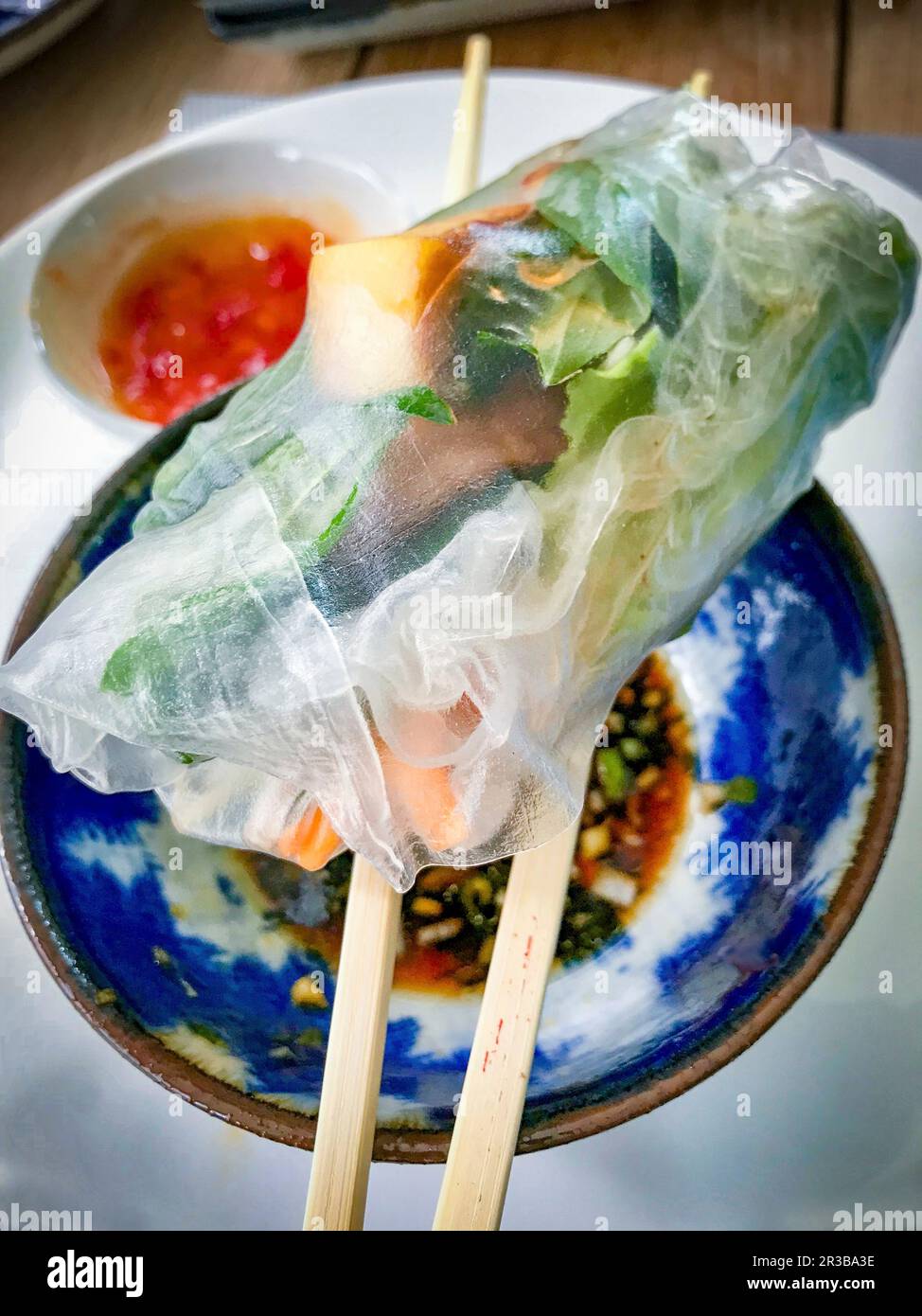 A Vietnamese spring roll on chopsticks Stock Photo - Alamy