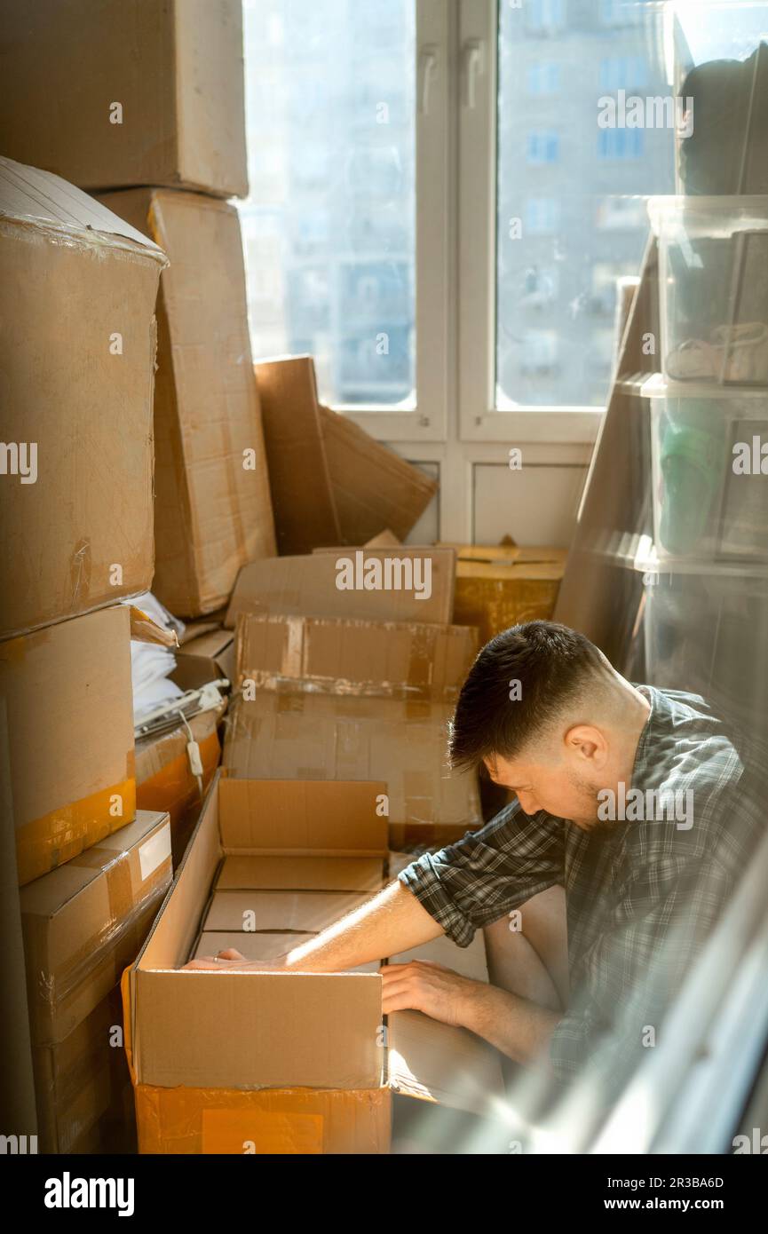 Man packing cardboard boxes for moving house Stock Photo - Alamy