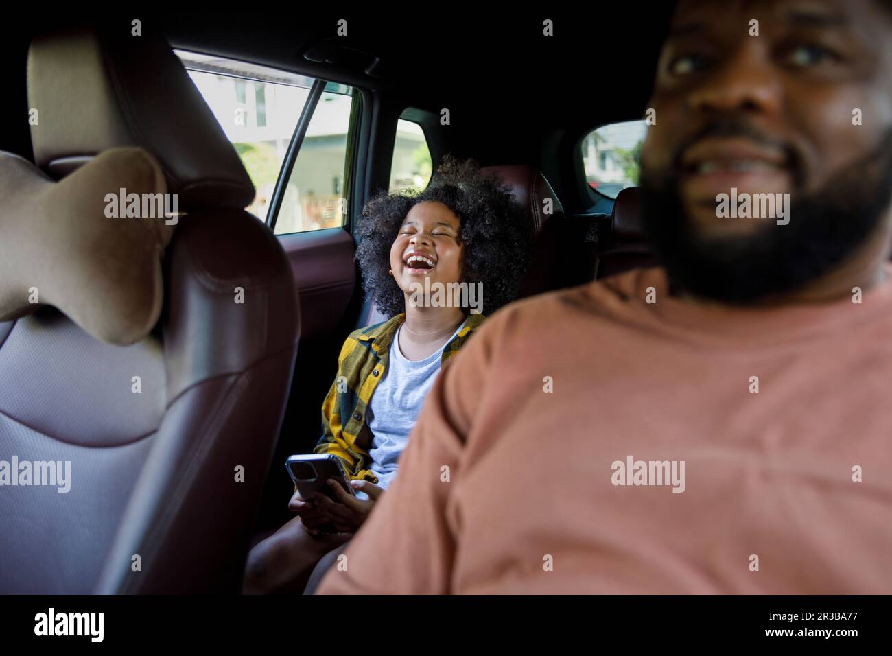 Happy girl sitting in back seat of car Stock Photo - Alamy