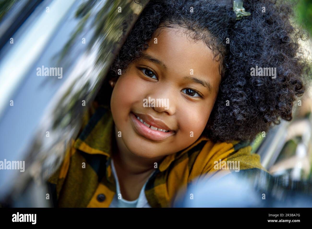 Smiling girl with curly hair in car Stock Photo - Alamy