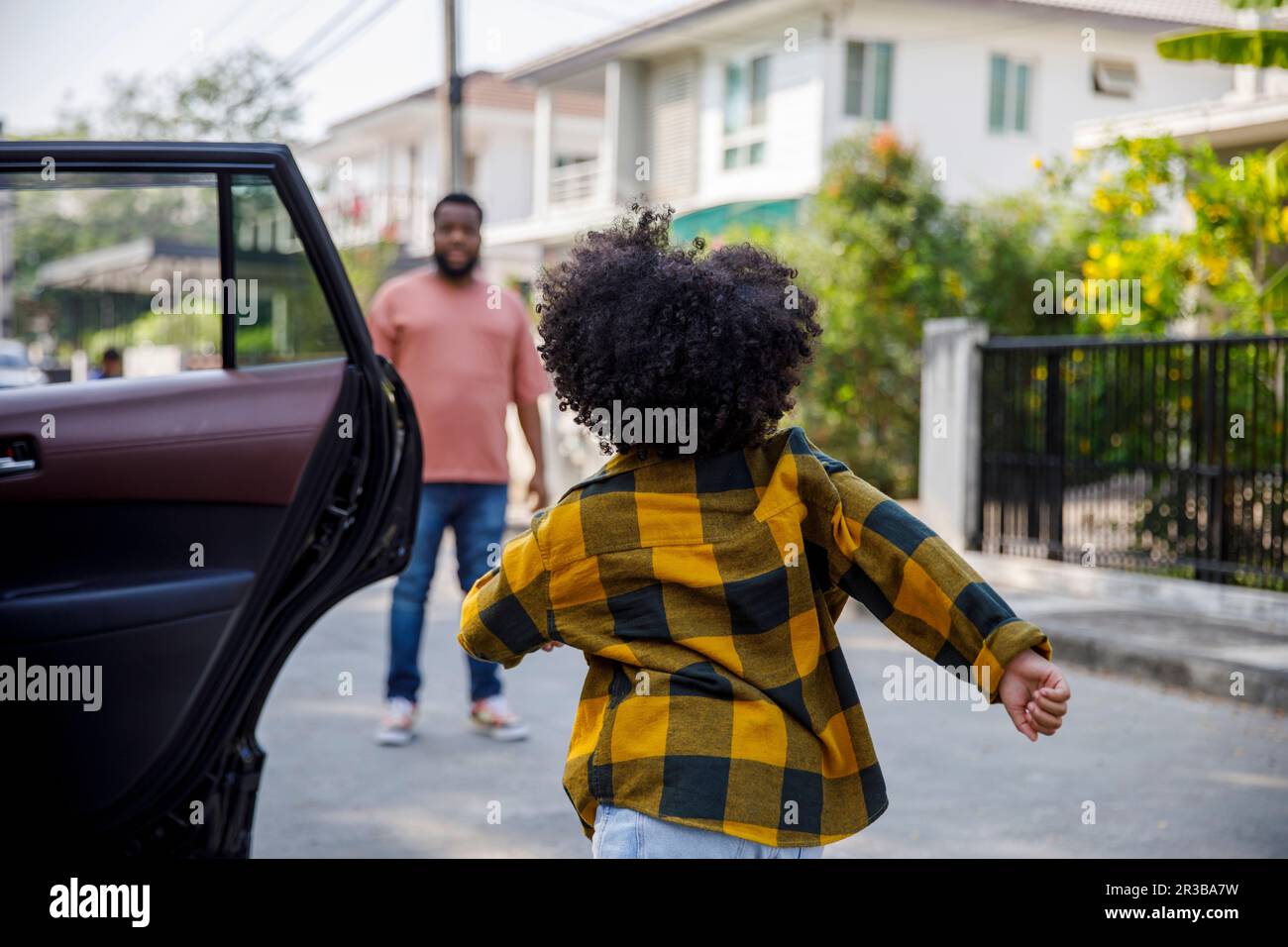 Girl running towards father standing on road Stock Photo - Alamy