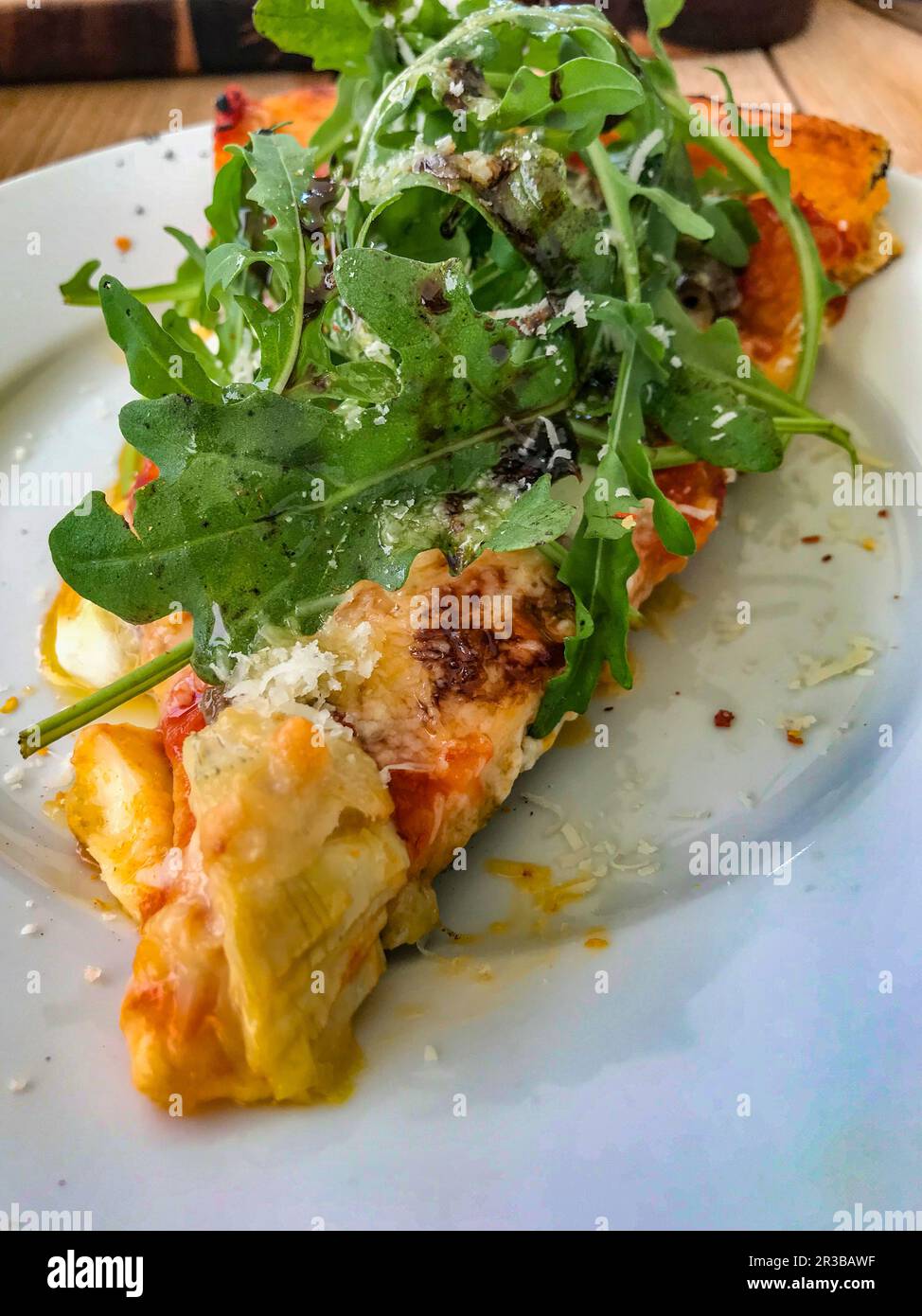 A slice of pizza with rocket and parmesan Stock Photo - Alamy